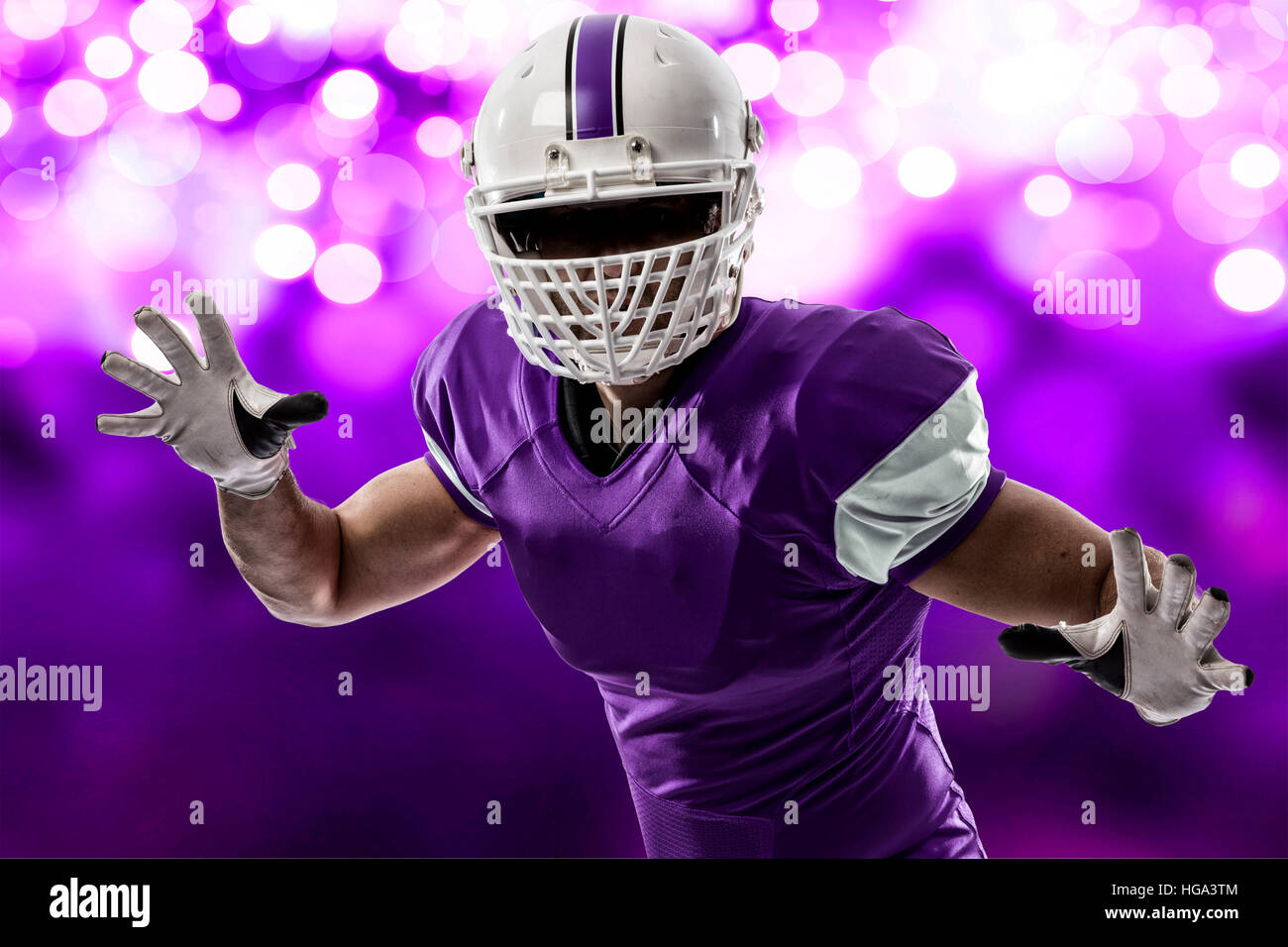 Football Player with a purple uniform making a tackle on a purple ...