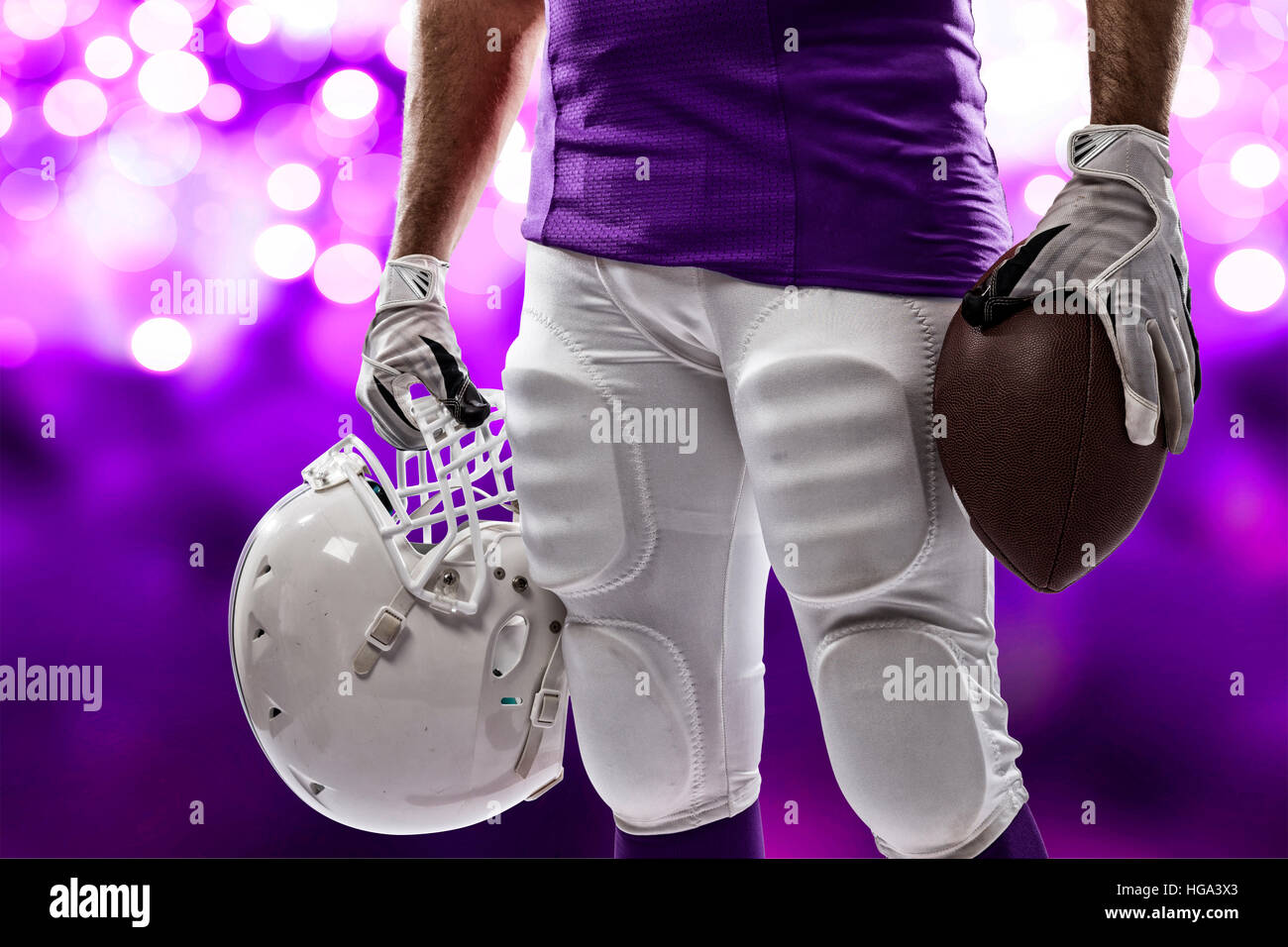 Football Player with a purple uniform on a purple lights background ...