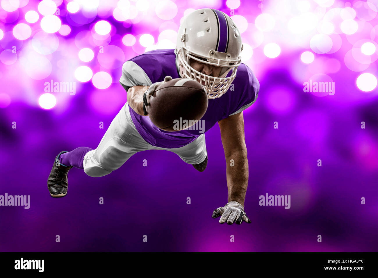 Football Player with a purple uniform scoring on a purple lights ...