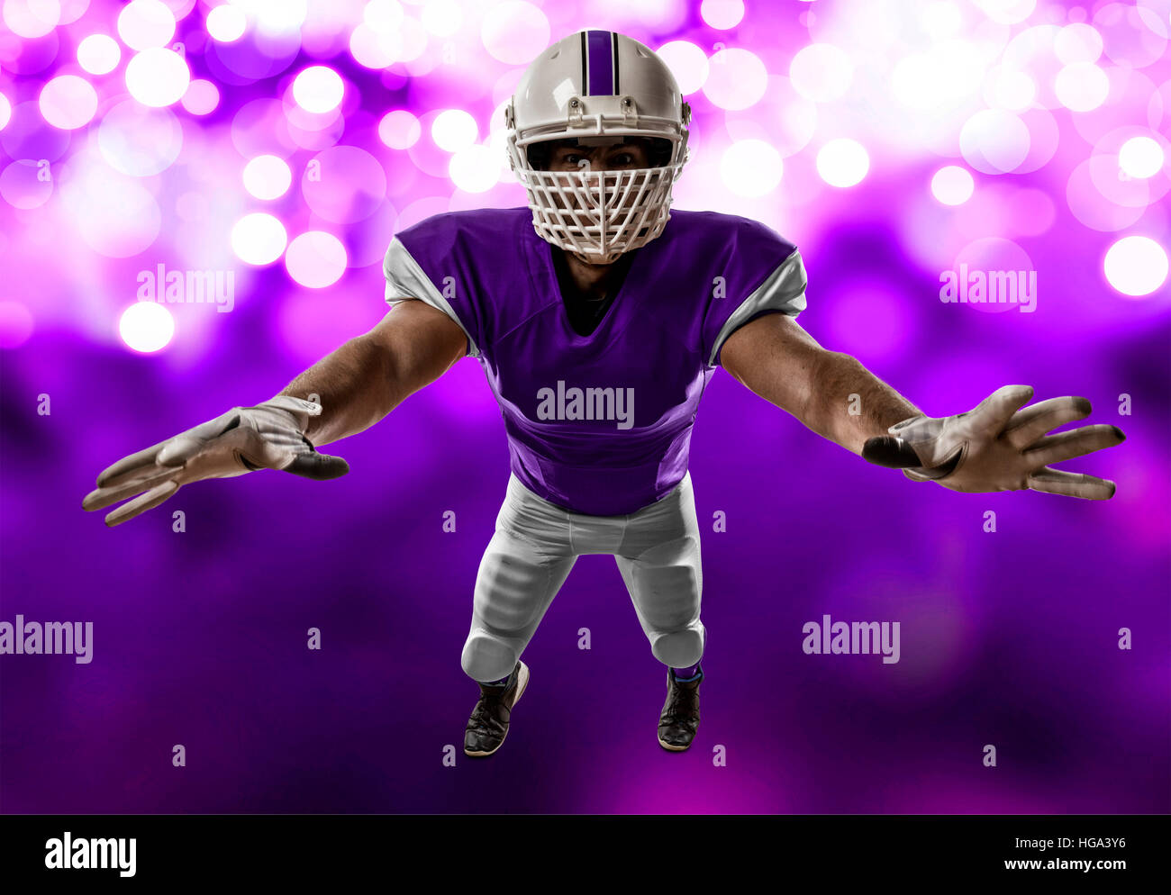 Football Player with a purple uniform making a tackle on a purple ...