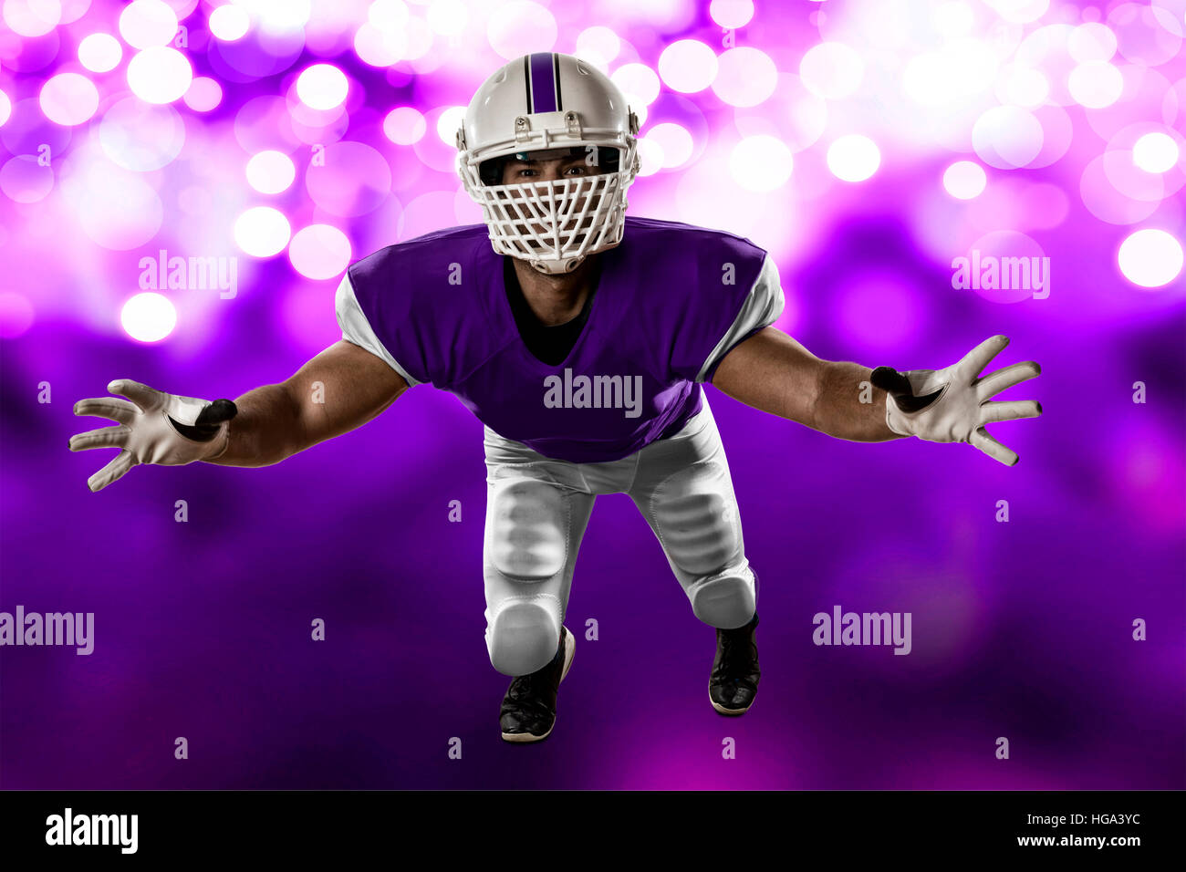 Football Player with a purple uniform making a tackle on a purple ...