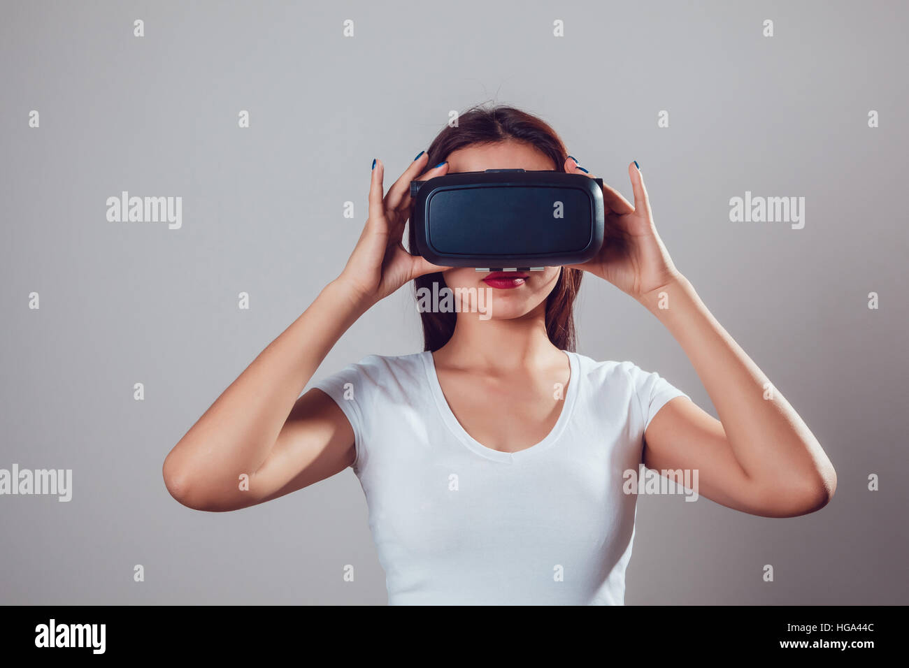 Attractive woman using virtual reality goggles on grey background. VR headset Stock Photo - Alamy