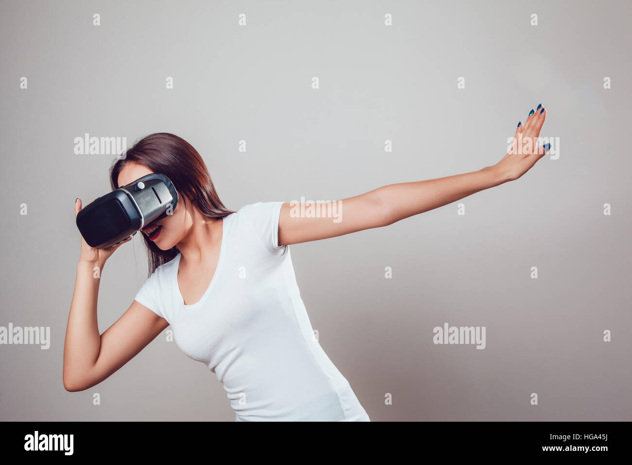 Attractive woman using virtual reality goggles on grey background. VR headset Stock Photo - Alamy