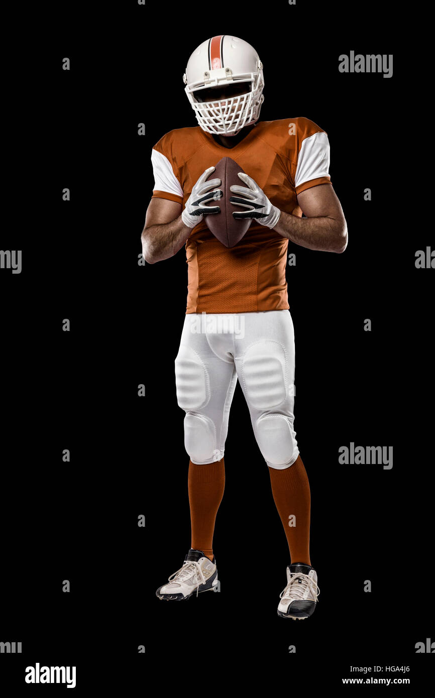 Football Player with a orange uniform on a black background Stock Photo ...