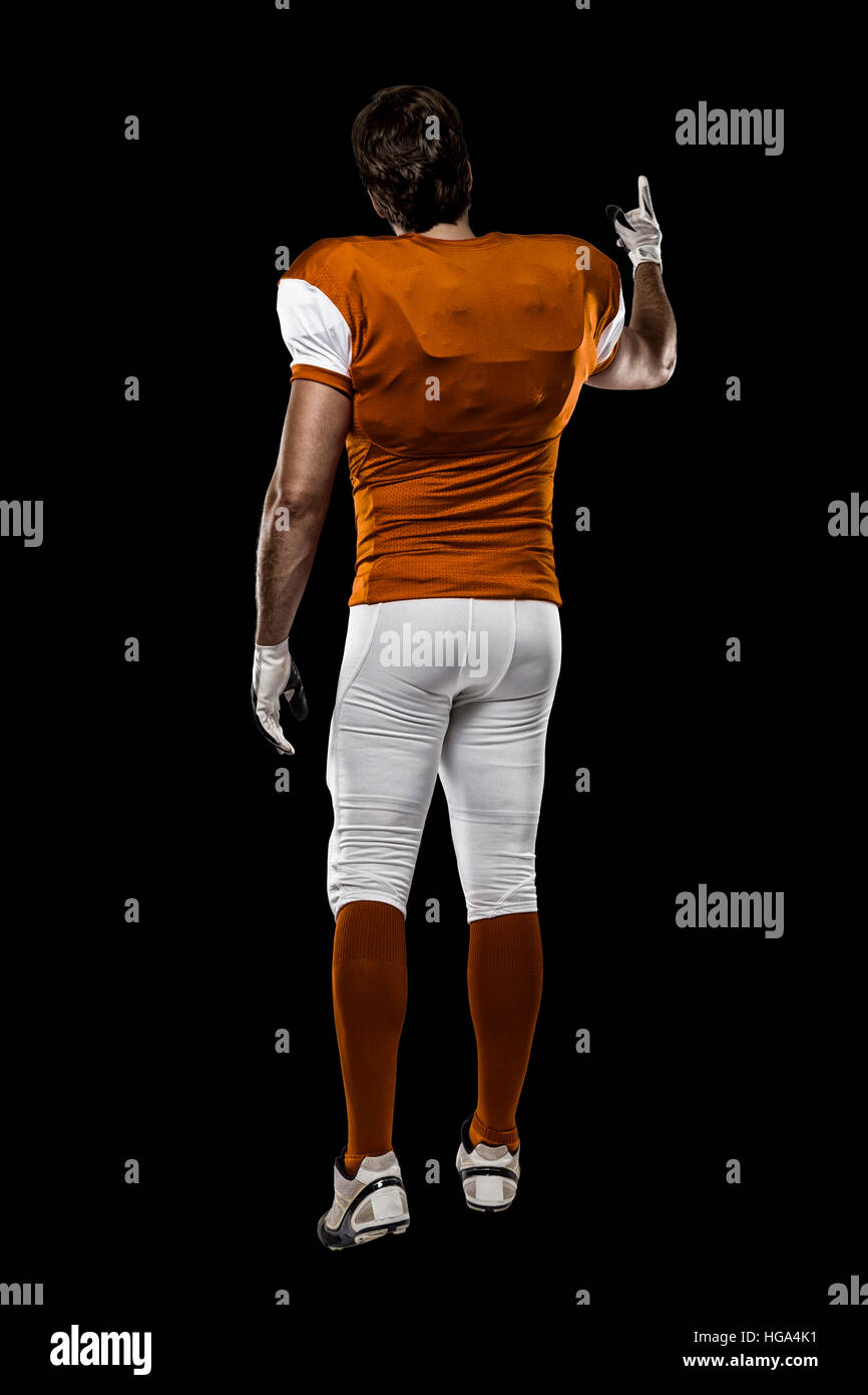 Football Player with a orange uniform walking, showing his back on a ...