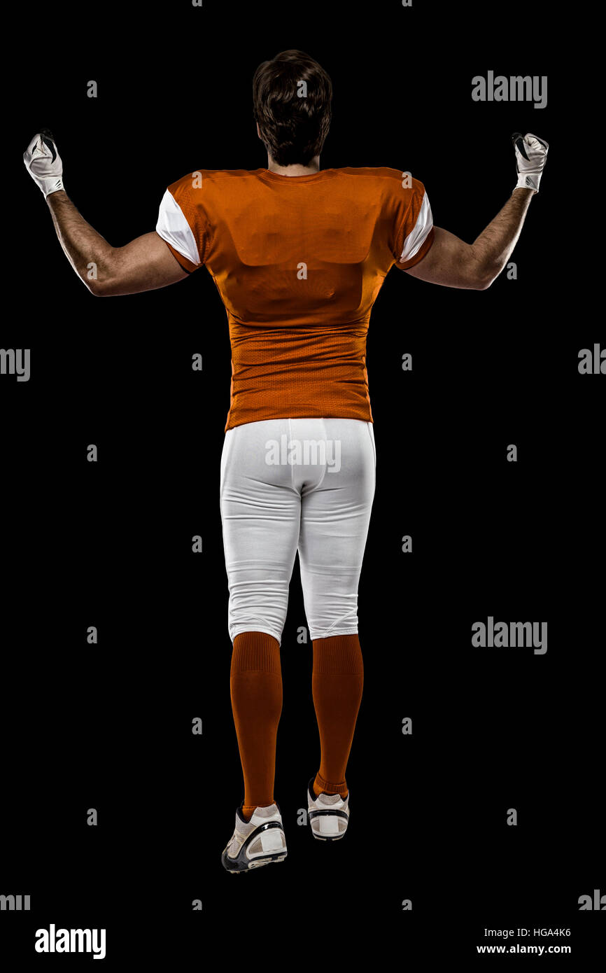Football Player with a orange uniform walking, showing his back on a ...