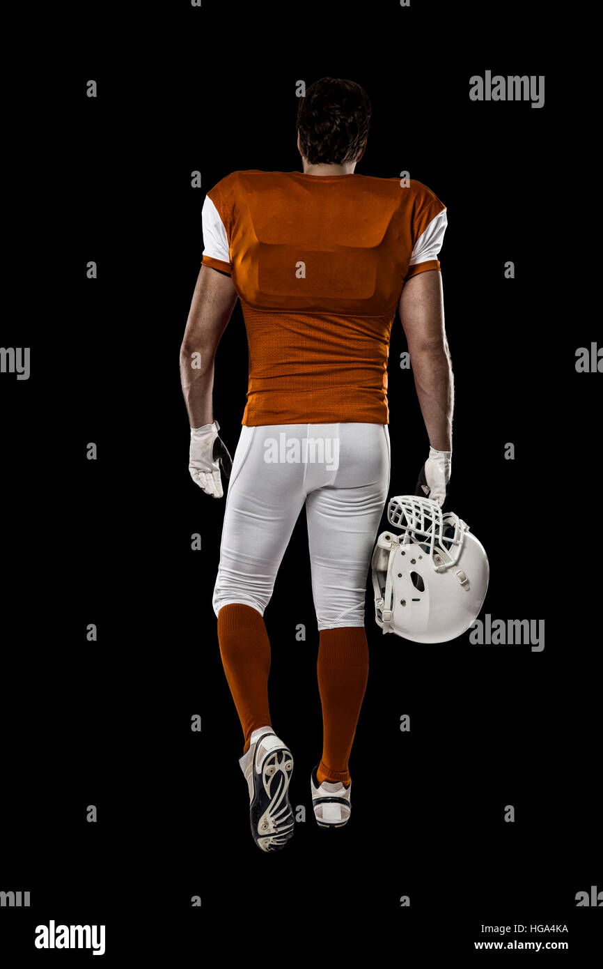 Football Player with a orange uniform walking, showing his back on a ...