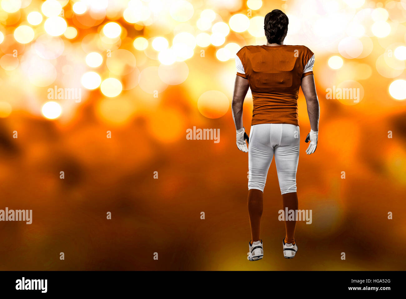 Football Player with a orange uniform walking, showing his back on a ...