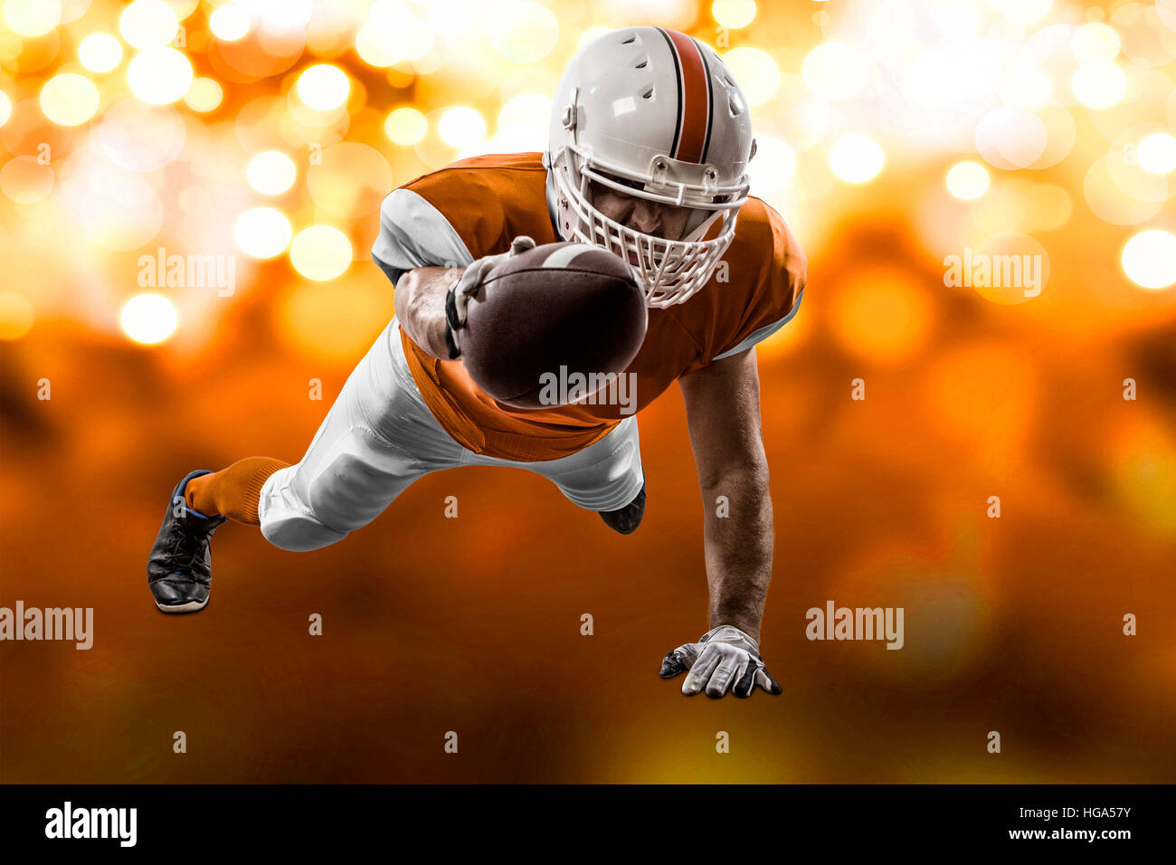 Football Player with a orange uniform scoring on a orange lights ...