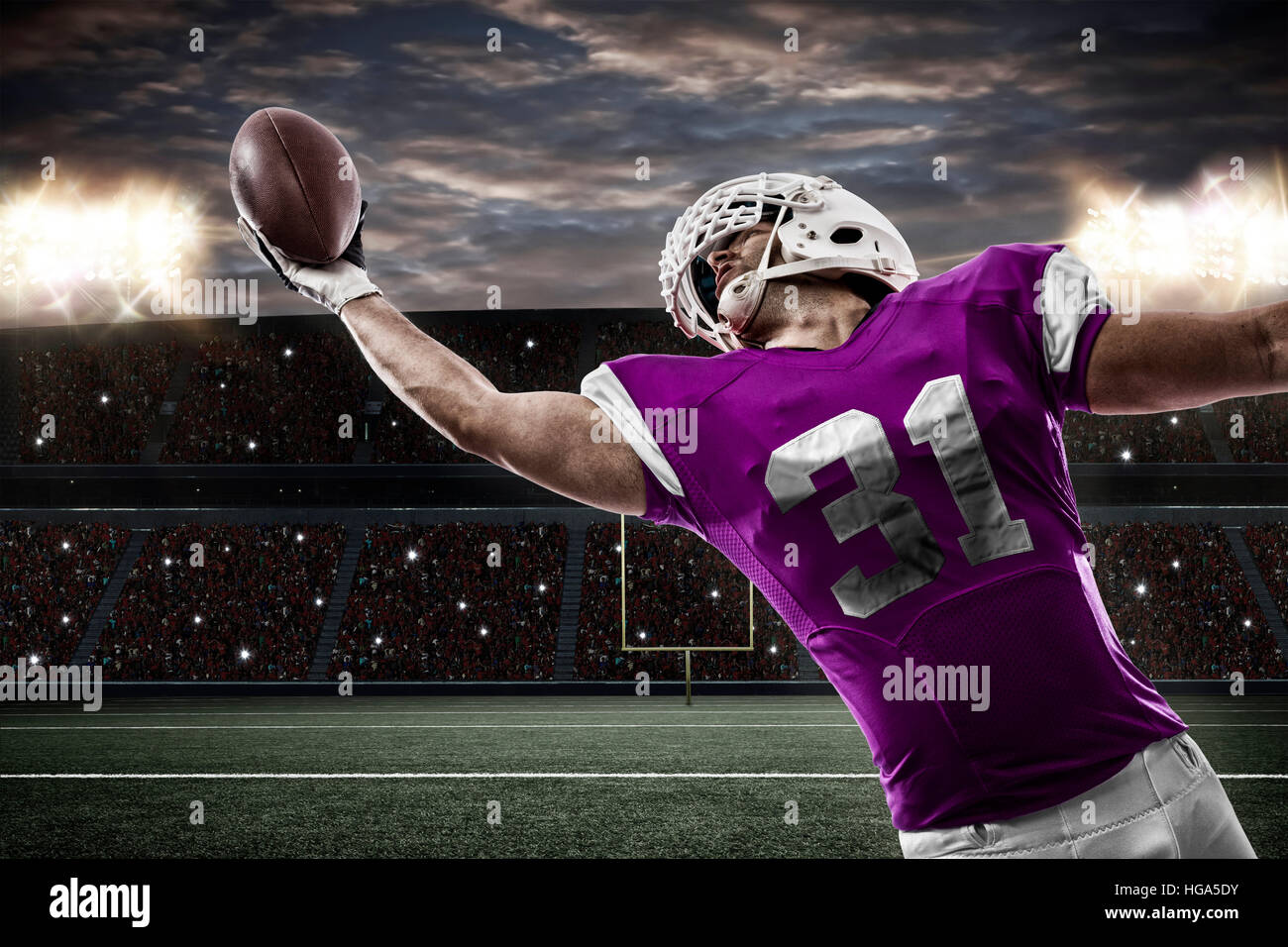 Football Player with a pink uniform catching a ball on a stadium Stock ...