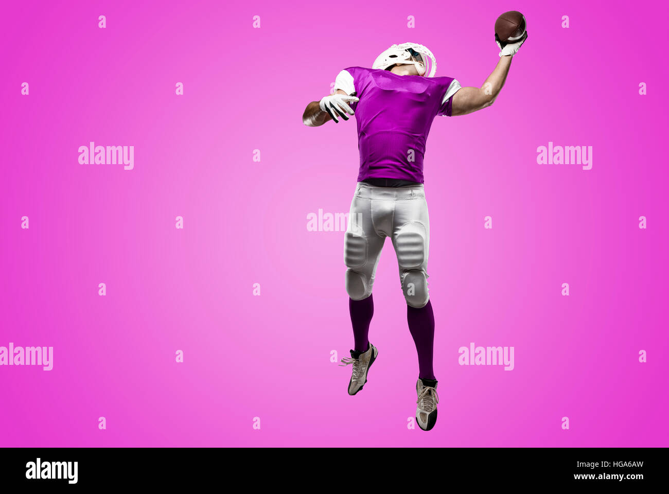 Football Player with a pink uniform making a catch on a pink background ...