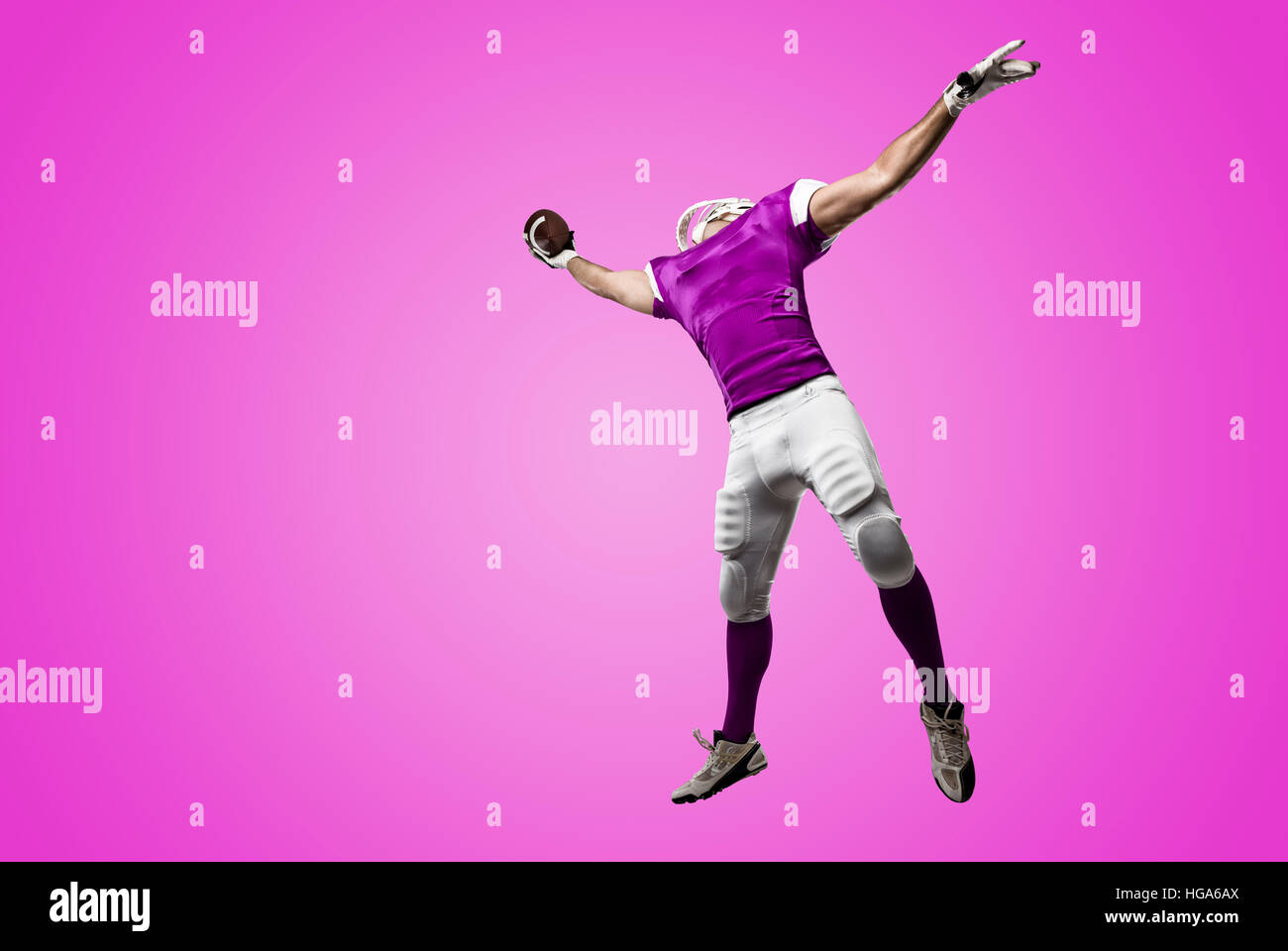 Football Player with a pink uniform making a catch on a pink background ...