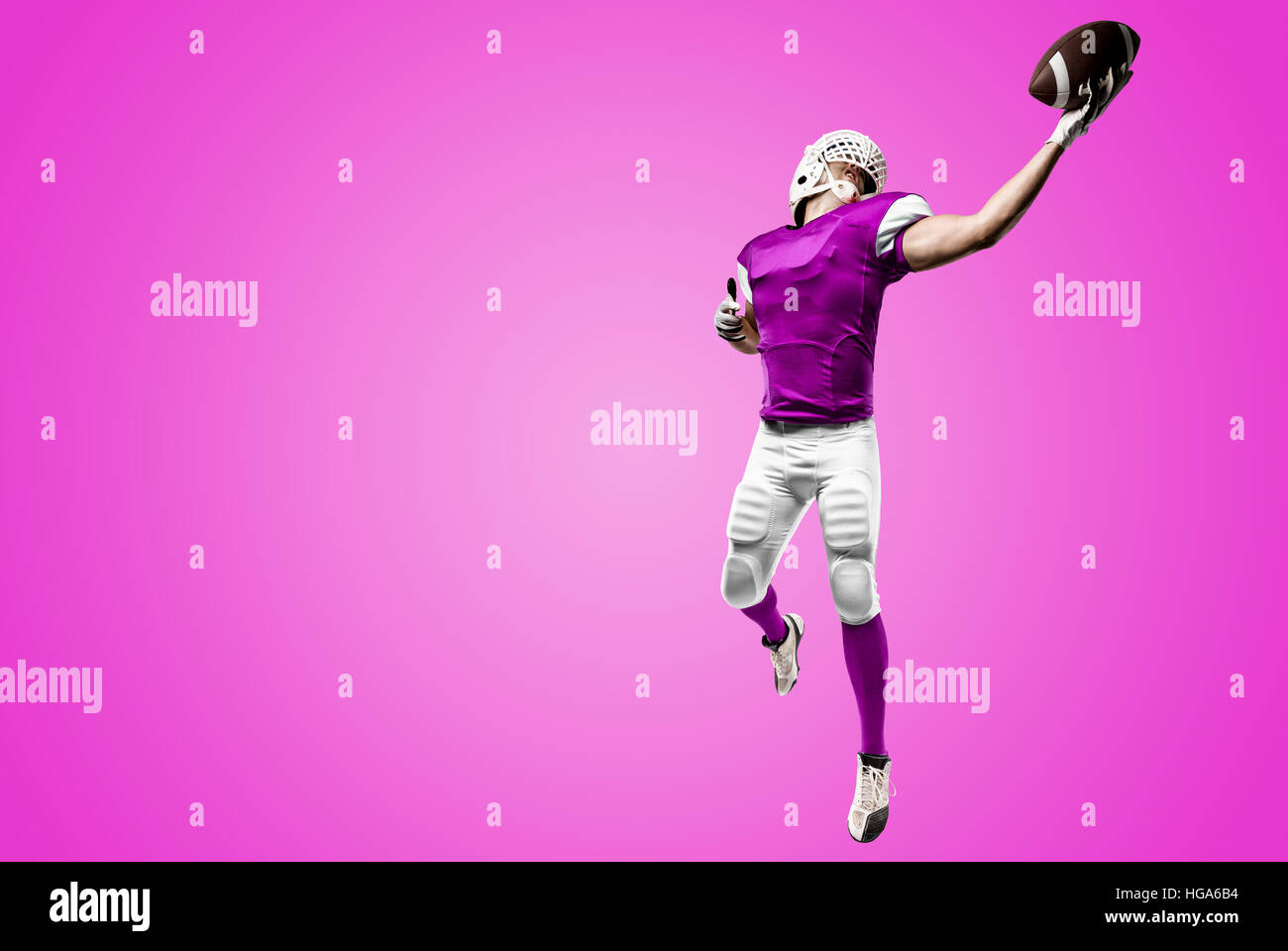 Football Player with a pink uniform making a catch on a pink background ...