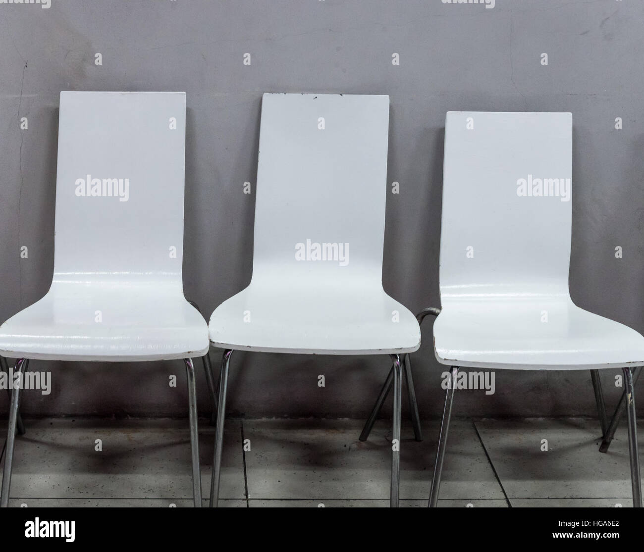 Dirty white chair with metal leg near the office wall Stock Photo - Alamy