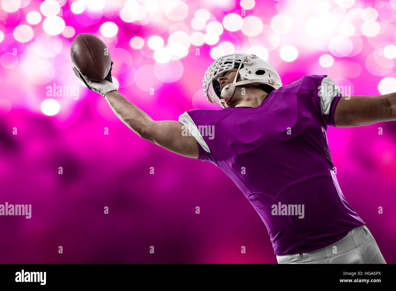 Football Player with a pink uniform making a catch on a pink lights ...
