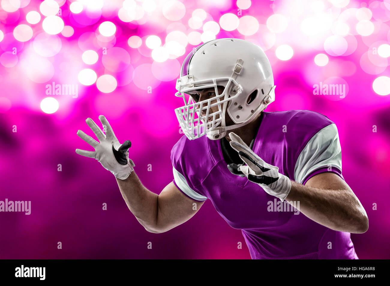 Football Player with a pink uniform making a tackle on a pink lights ...