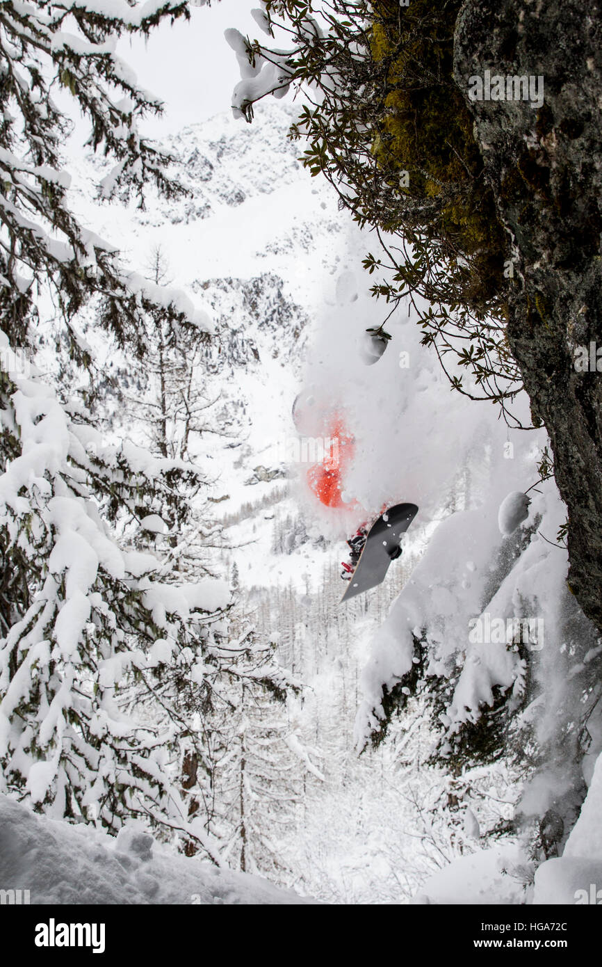 A Snowboarder Jumping Off A Cliff And Dropping Fresh Snow Stock Photo ...