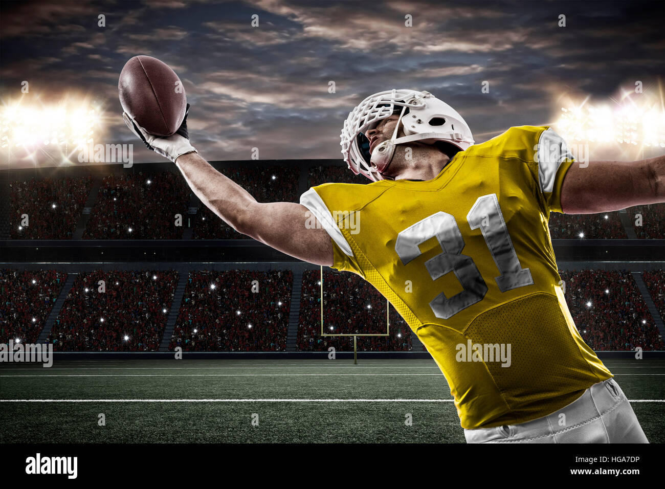 Football Player with a yellow uniform catching a ball on a stadium ...