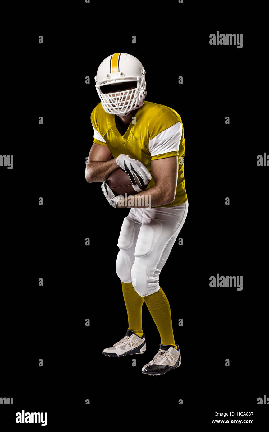 Football Player with a yellow uniform on a black background Stock Photo ...