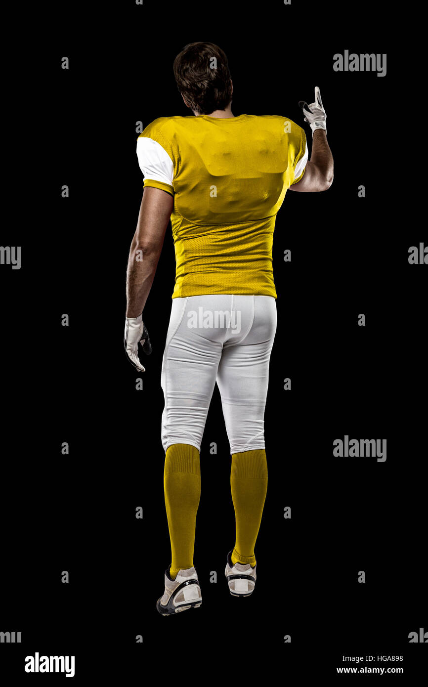 Football Player with a yellow uniform walking, showing his back on a ...