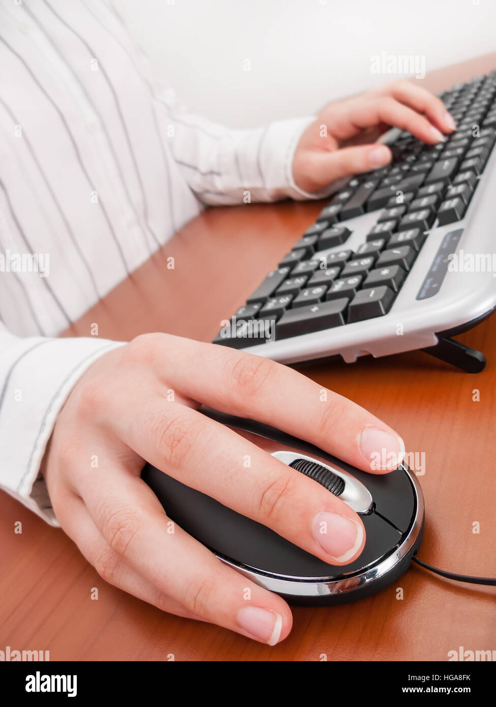 Businesswoman or female secretary sitting at the desk, typing on the ...