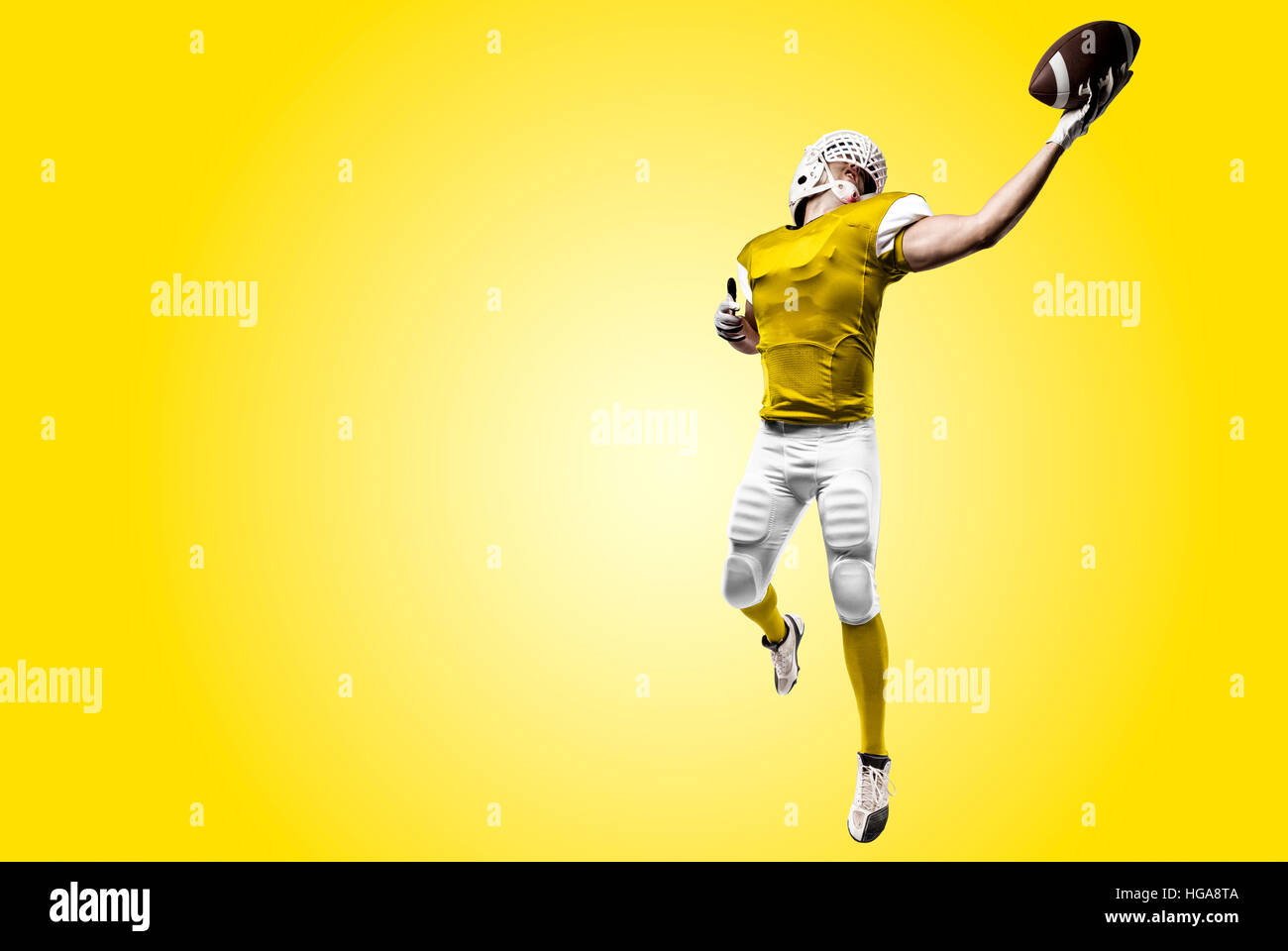 Football Player with a yellow uniform making a catch on a yellow ...