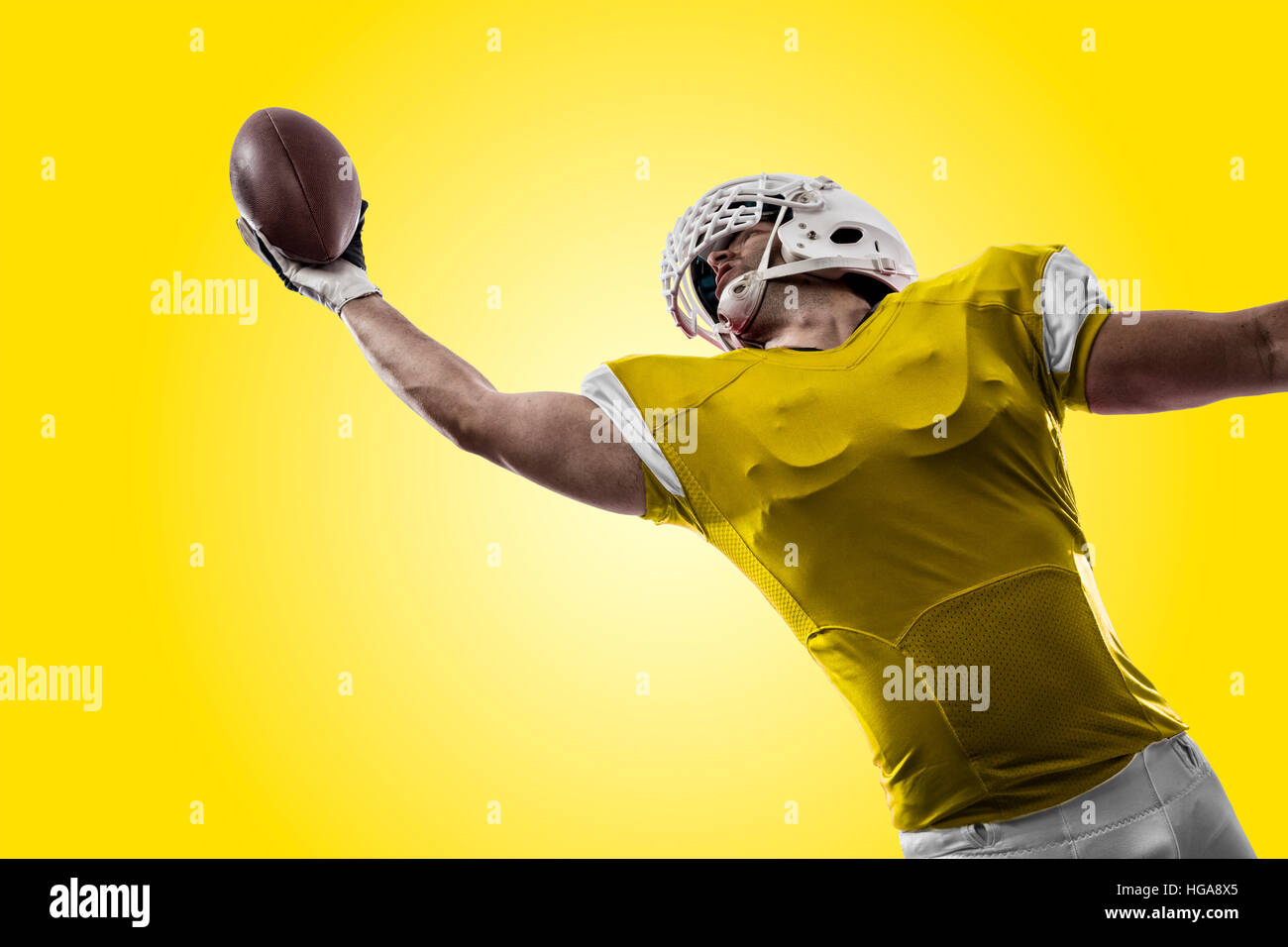 Football Player with a yellow uniform making a catch on a yellow ...