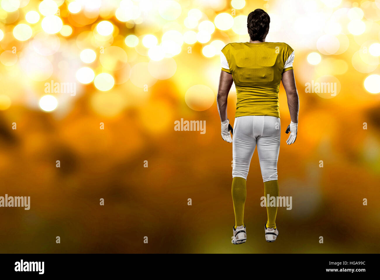 Football Player with a yellow uniform walking, showing his back on a ...