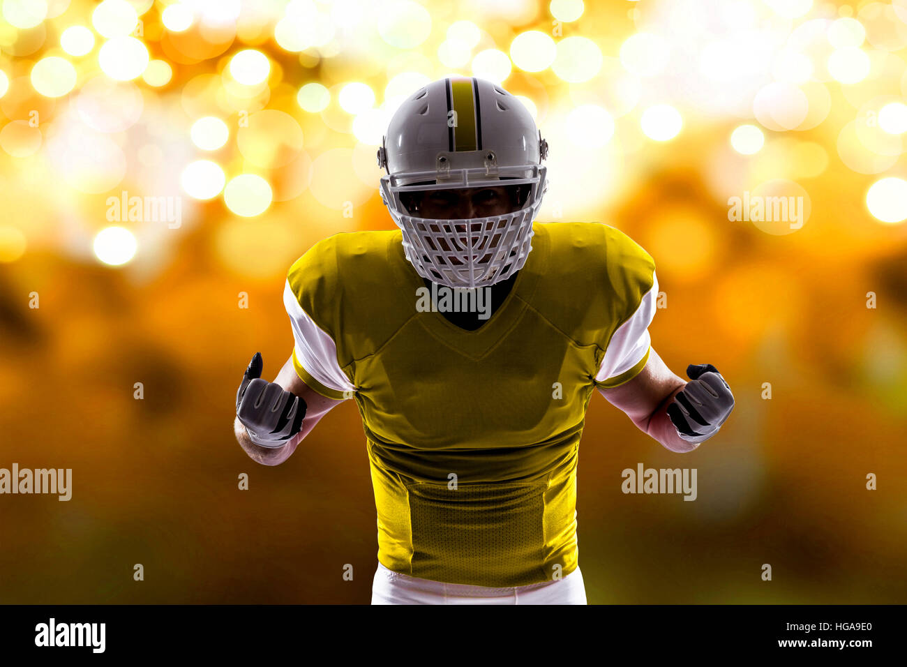 Football Player with a yellow uniform on a yellow lights background ...