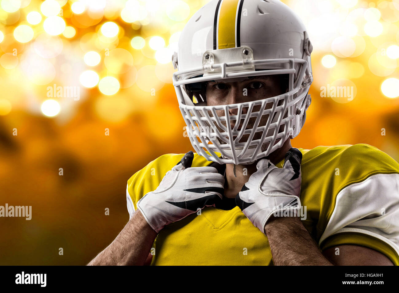 Football Player with a yellow uniform on a yellow lights background ...