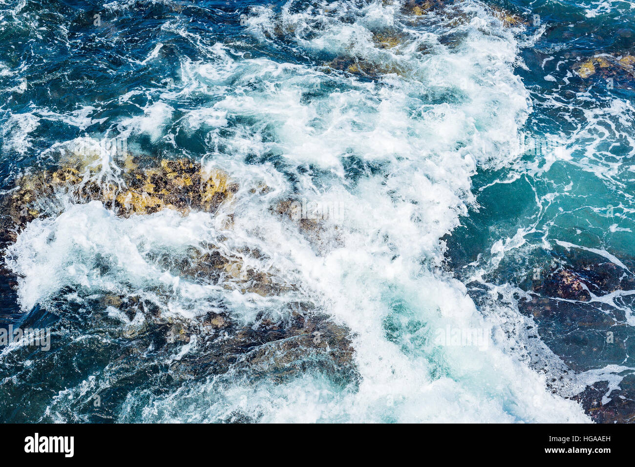 Ocean sea wave splash on rocky shore, lot of foam, dark blue water ...