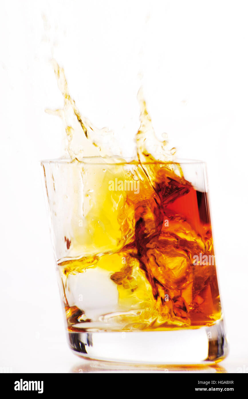 Ice cube falling into a glass of whiskey Stock Photo - Alamy