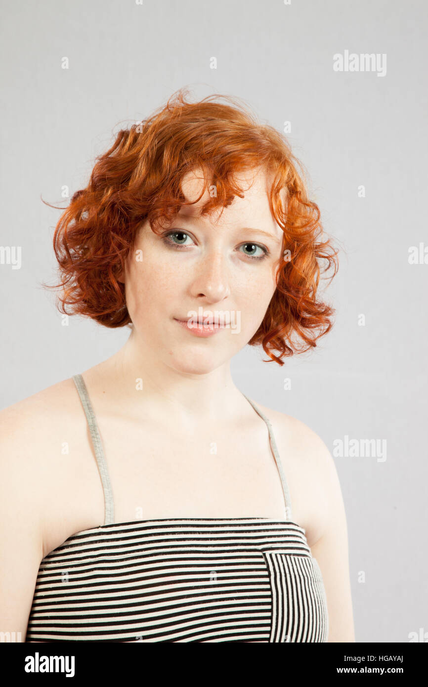 Pretty Redhead woman looking thoughtfully pleased Stock Photo - Alamy