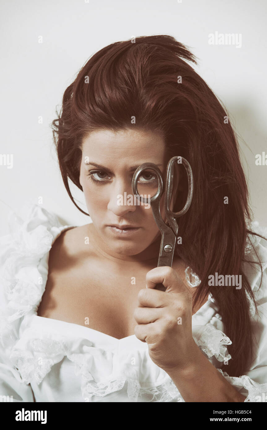 Portrait of an angry woman holding an old pair of scissors Stock Photo ...