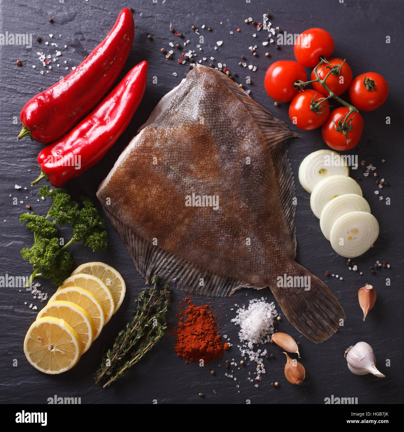 Fresh raw flatfish with ingredients on a slate board closeup. view from ...