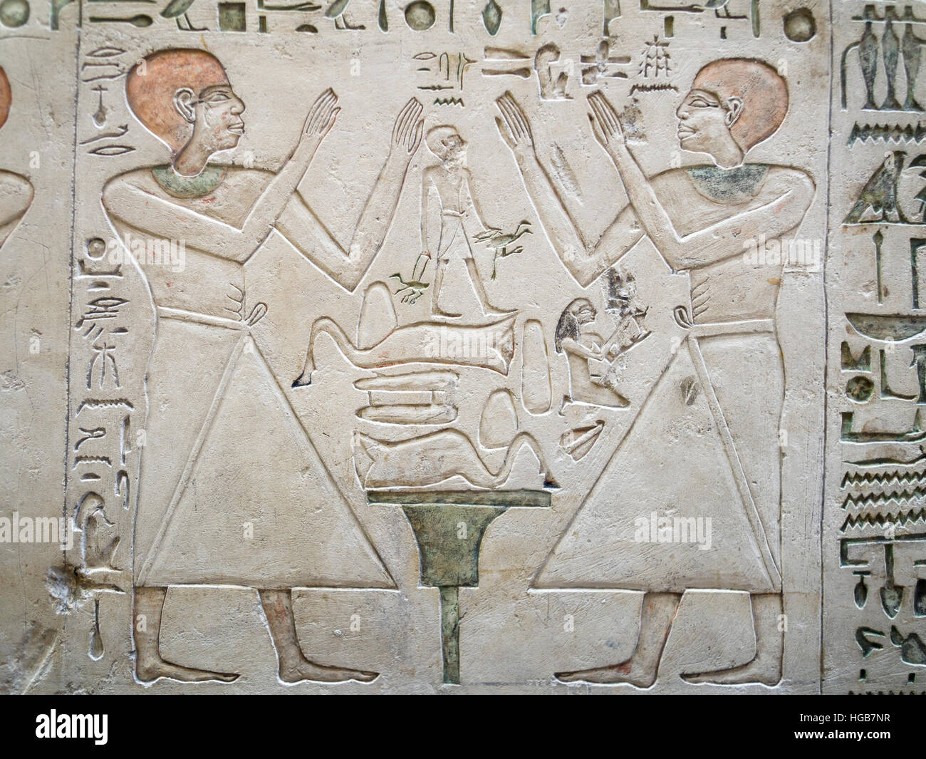 Egyptian clapping relief. A carved and painted stone relief of two men ...