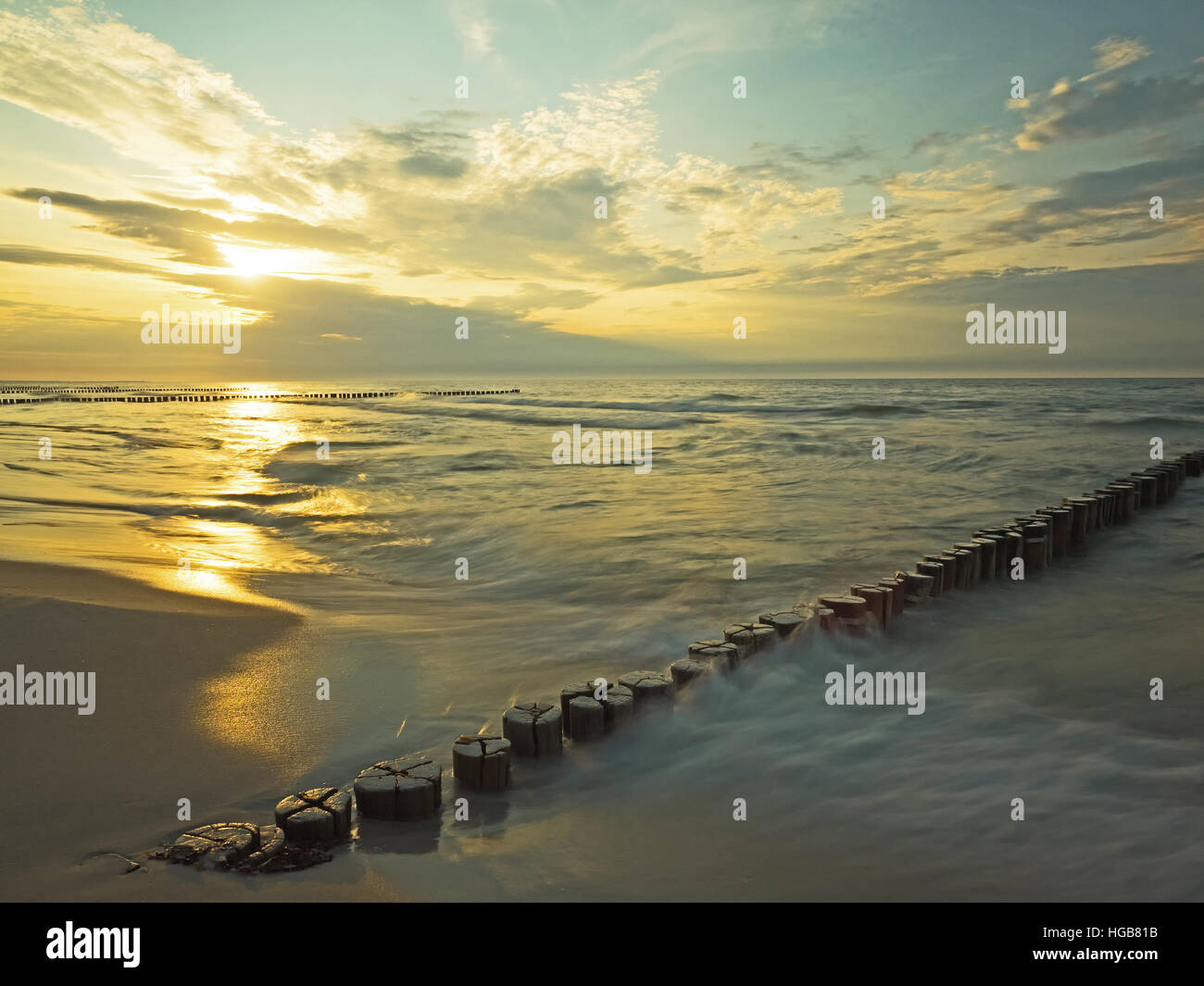 Baltic Sea with breakwaters at sunset Stock Photo - Alamy