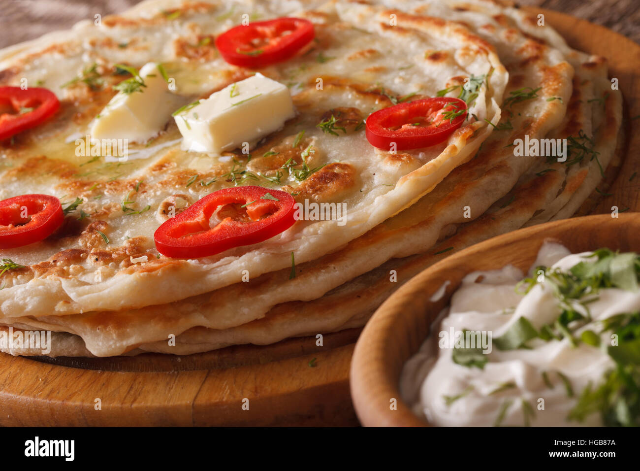 Indian paratha with butter and herbs macro on the table. Horizontal ...