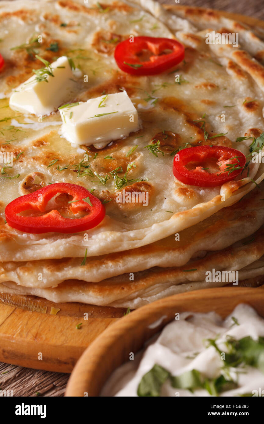 Indian paratha with butter and herbs macro on the table. vertical Stock ...