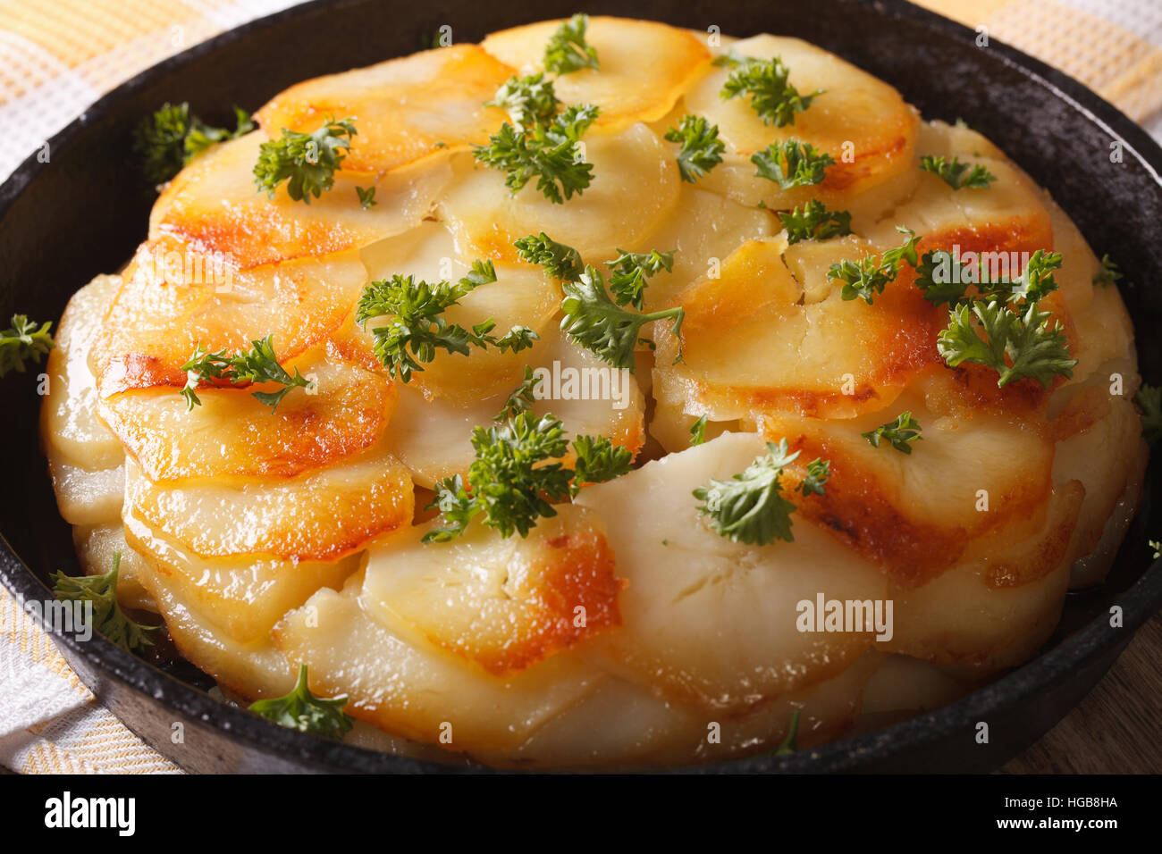 French Anna Potatoes baked in a pan close-up on the table. horizontal ...