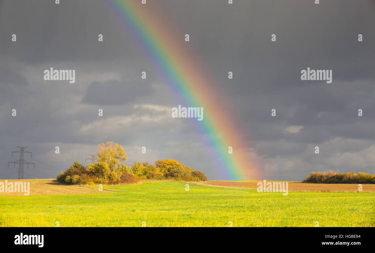 Natural rainbow over green field after heavy rain Stock Photo - Alamy