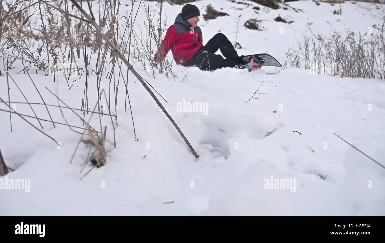 boy snowboarding fall rolling in the snow with sport holidays winter ...