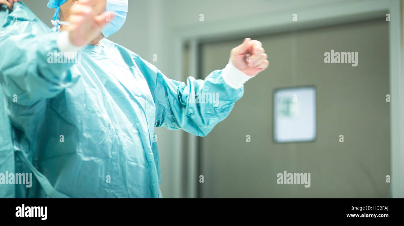 Surgeon in hospital surgery dressing in sterile uniform "scrubs" in ...