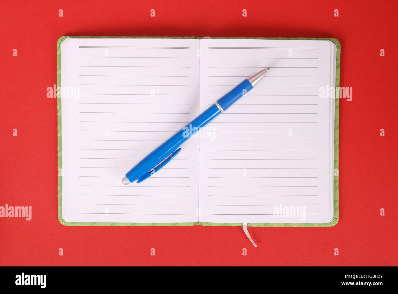 Green open notebook with blue pen isolated on white background red soft ...