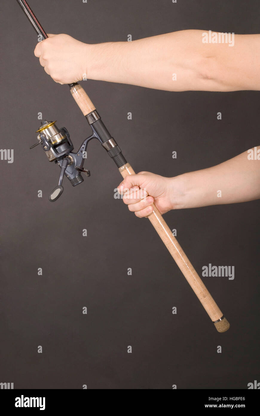 Man's hand holding a fishing rod on a black background Stock Photo - Alamy