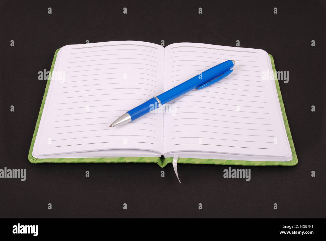 White notebook with blue pen isolated on black background Stock Photo ...