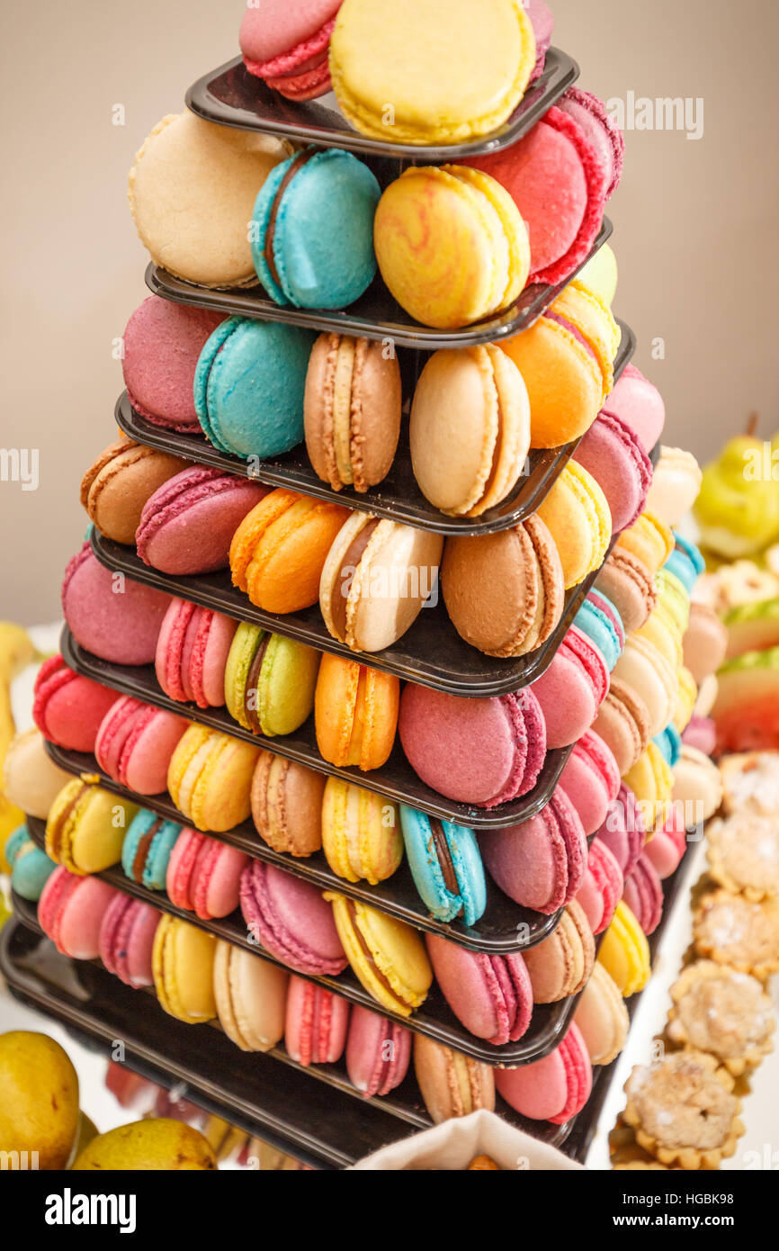 Colorful macarons on pyramid-shaped tower stand as part of candy bar ...