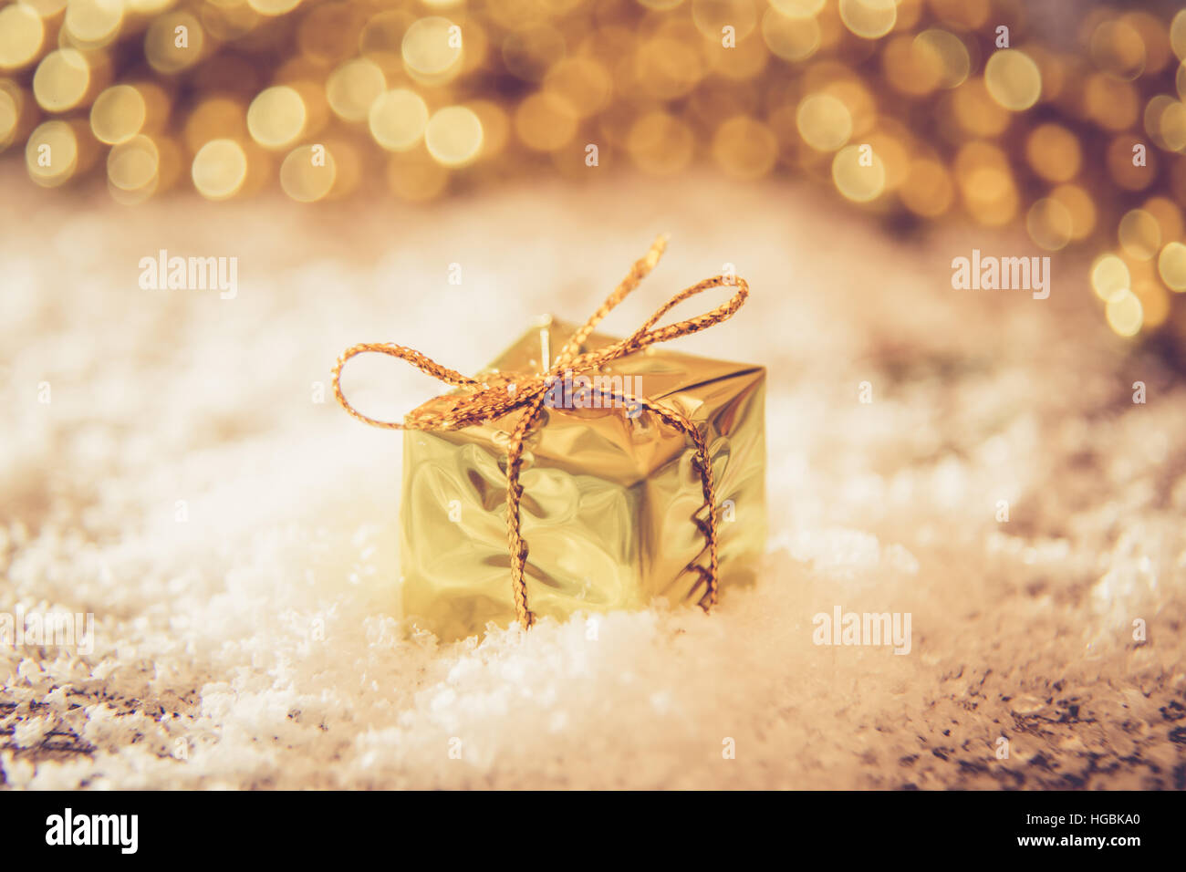 Christmas retro gold box in the snow with golden background light Stock ...