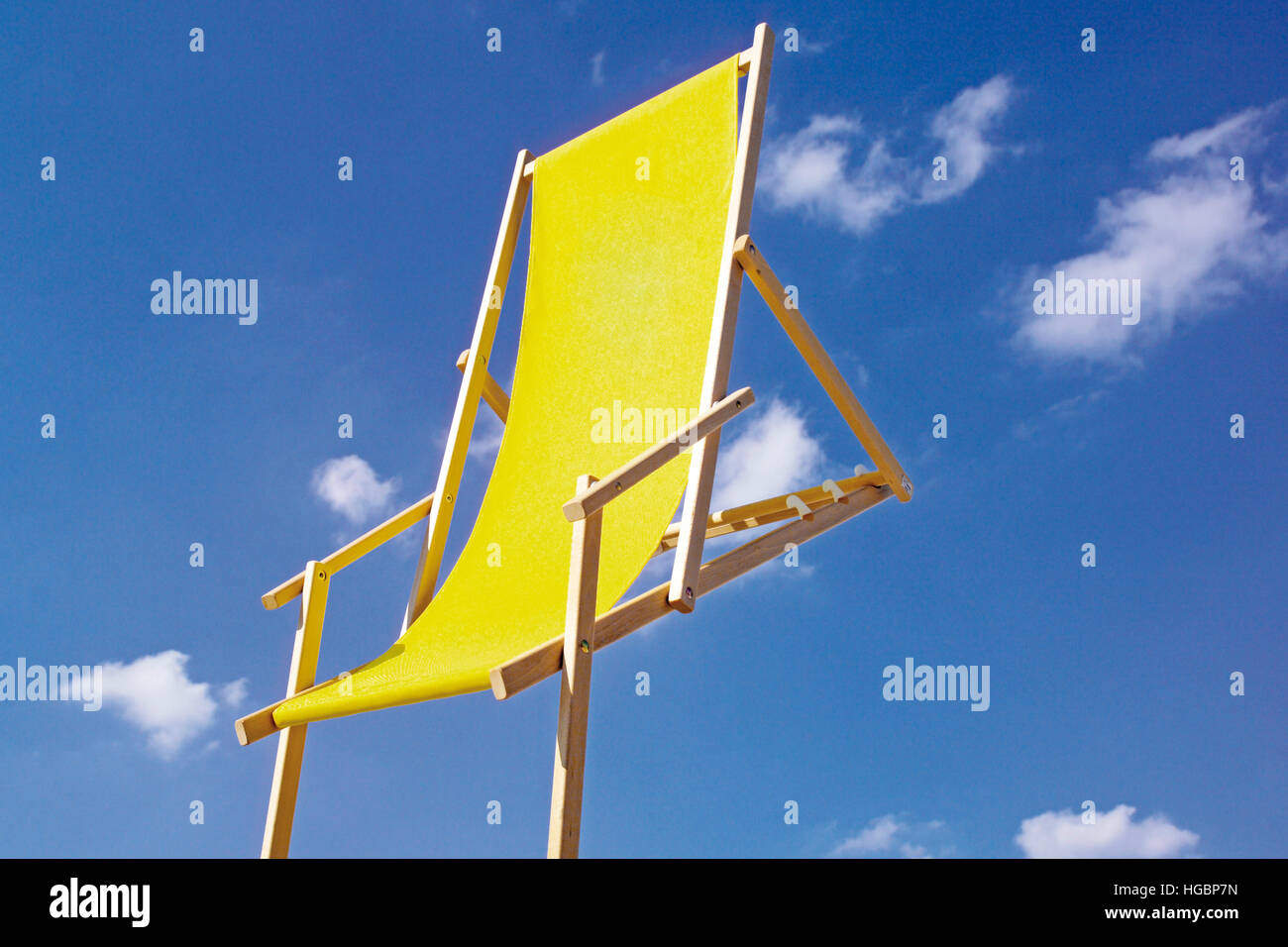 Yellow deck chair in front of a blue sky Stock Photo - Alamy