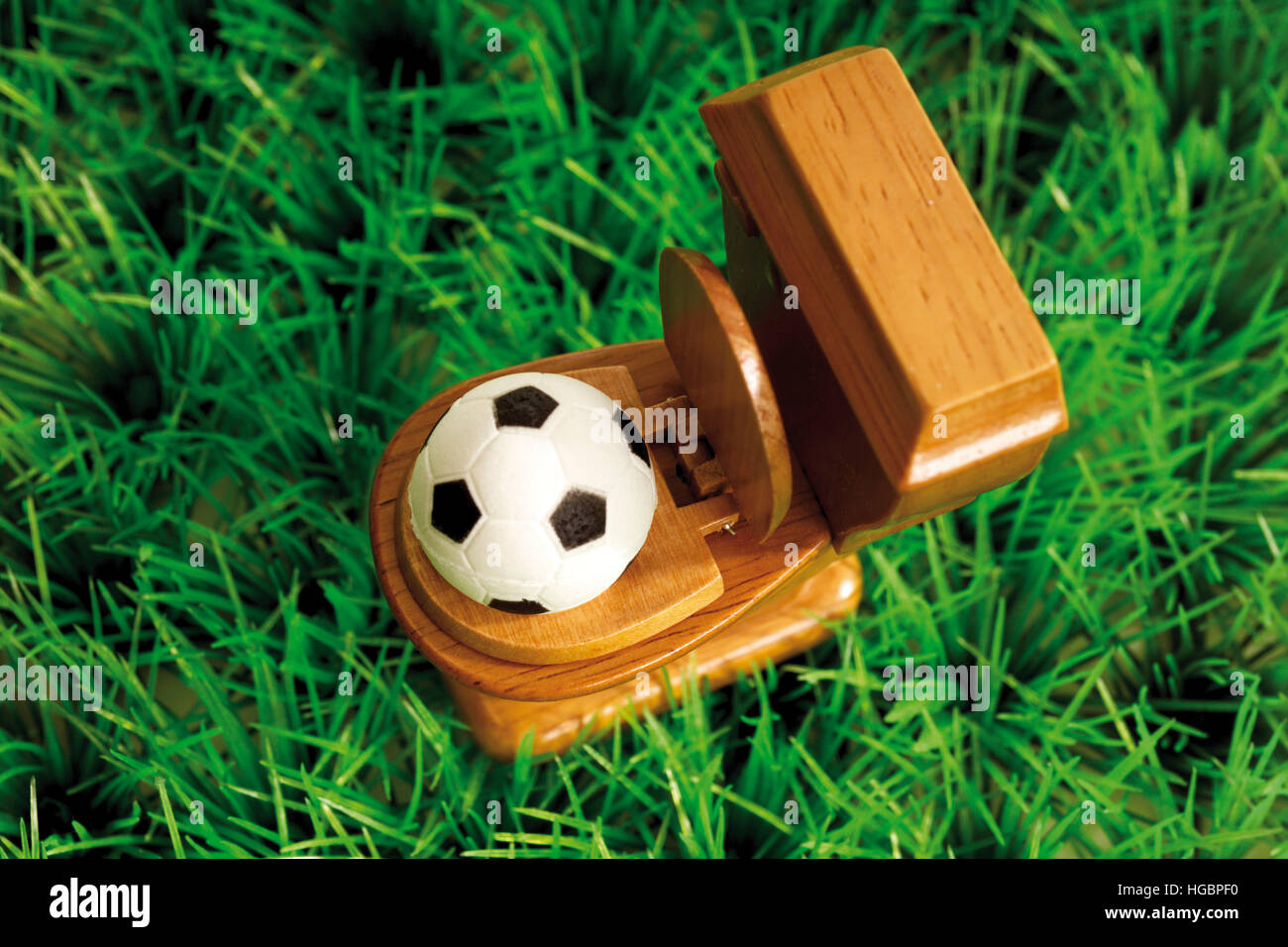 Football in the toilet: symbol for losing the ball Stock Photo - Alamy